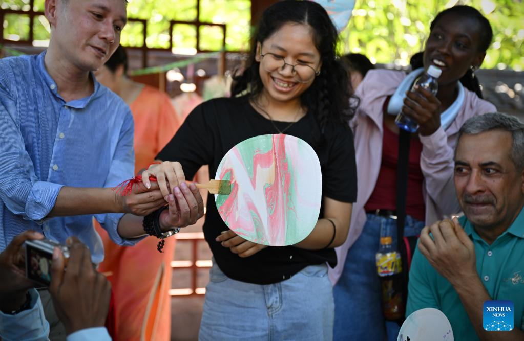 Foreigners learn to make traditional Chinese lacquer fans in Haikou | 极目新闻