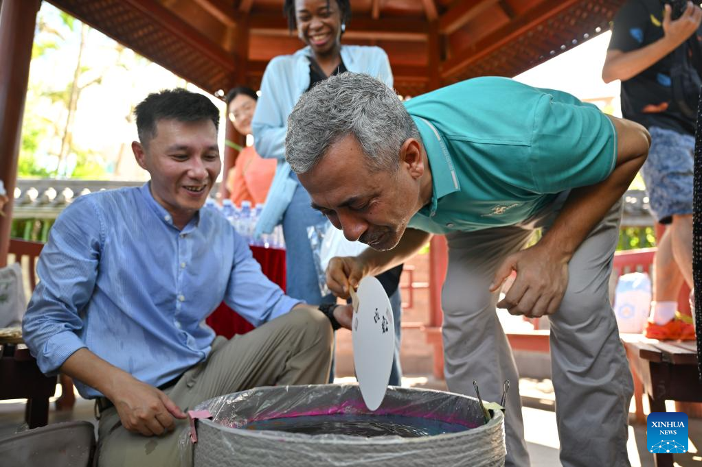 Foreigners learn to make traditional Chinese lacquer fans in Haikou | 极目新闻
